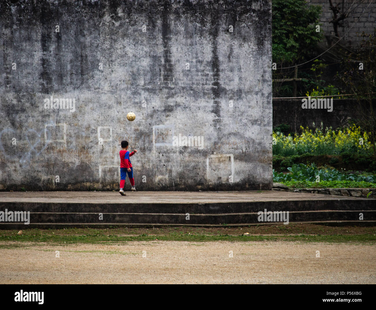 Ha Giang, Vietnam - March 18, 2018: Child playing football against a ...
