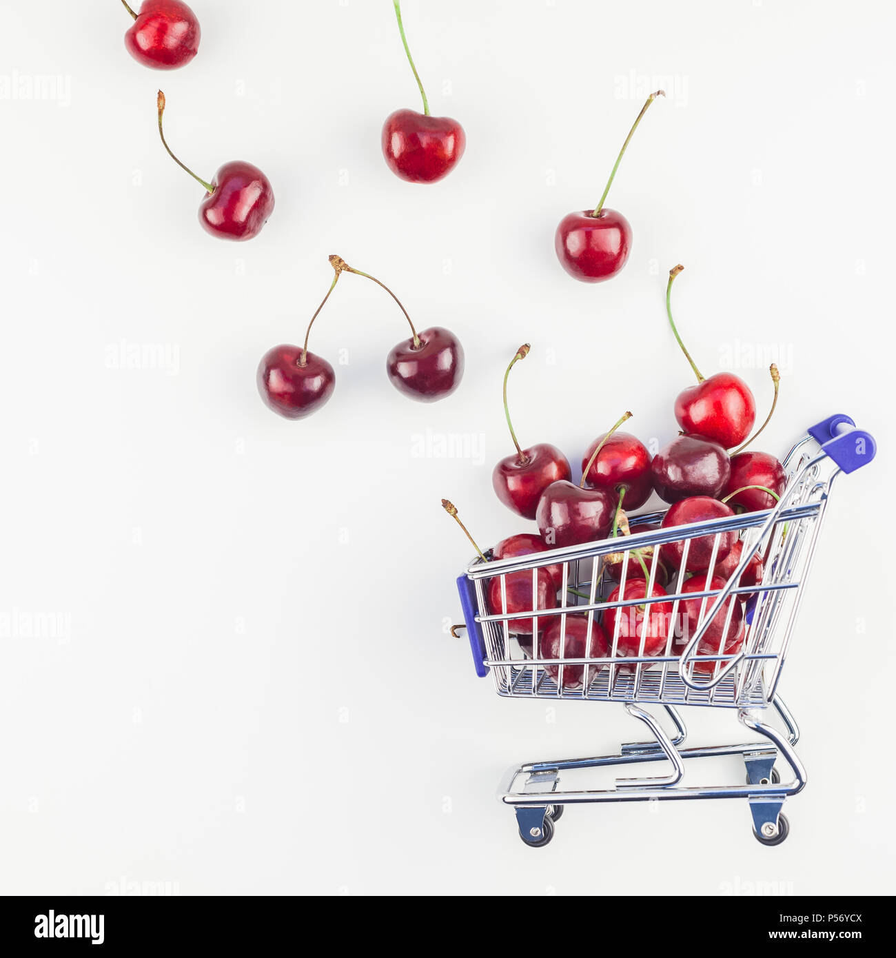 Square image of ripe cherries in a shopping cart with copy space ...