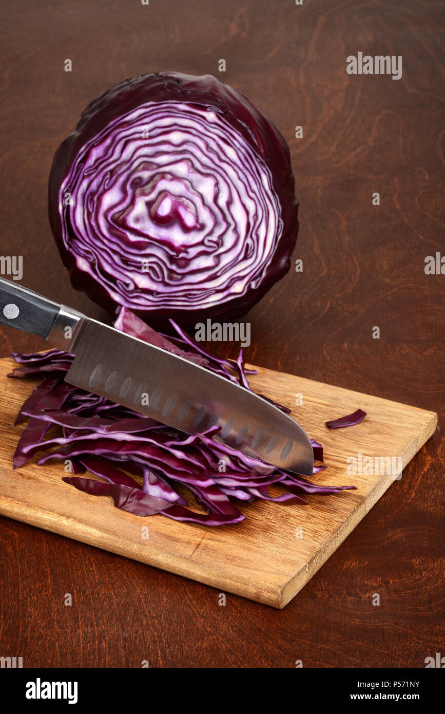 slicing red cabbage with kitchen knife Stock Photo - Alamy