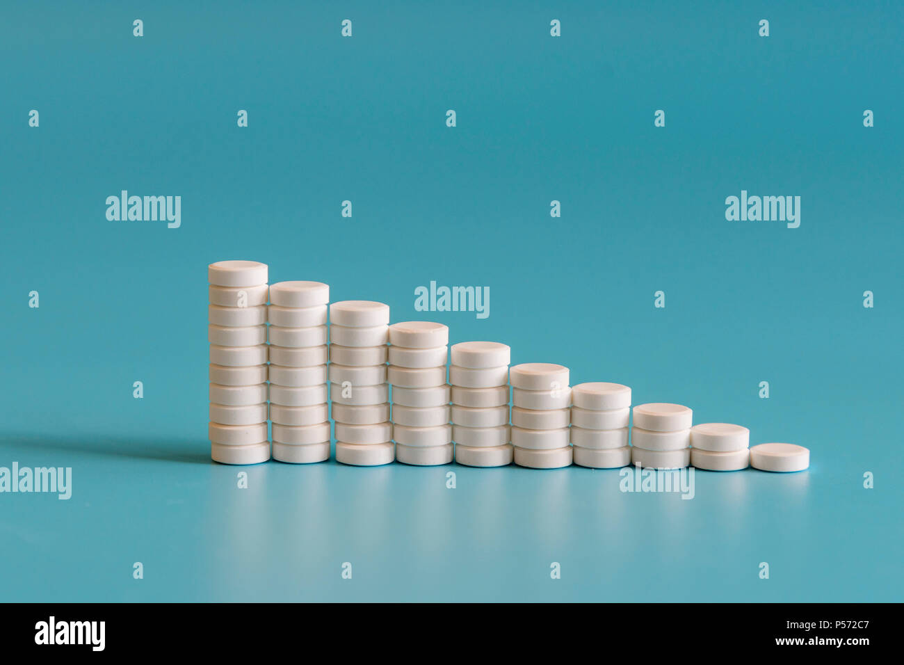 A stack of pills on a blue background. Growth graph made of stacked ...