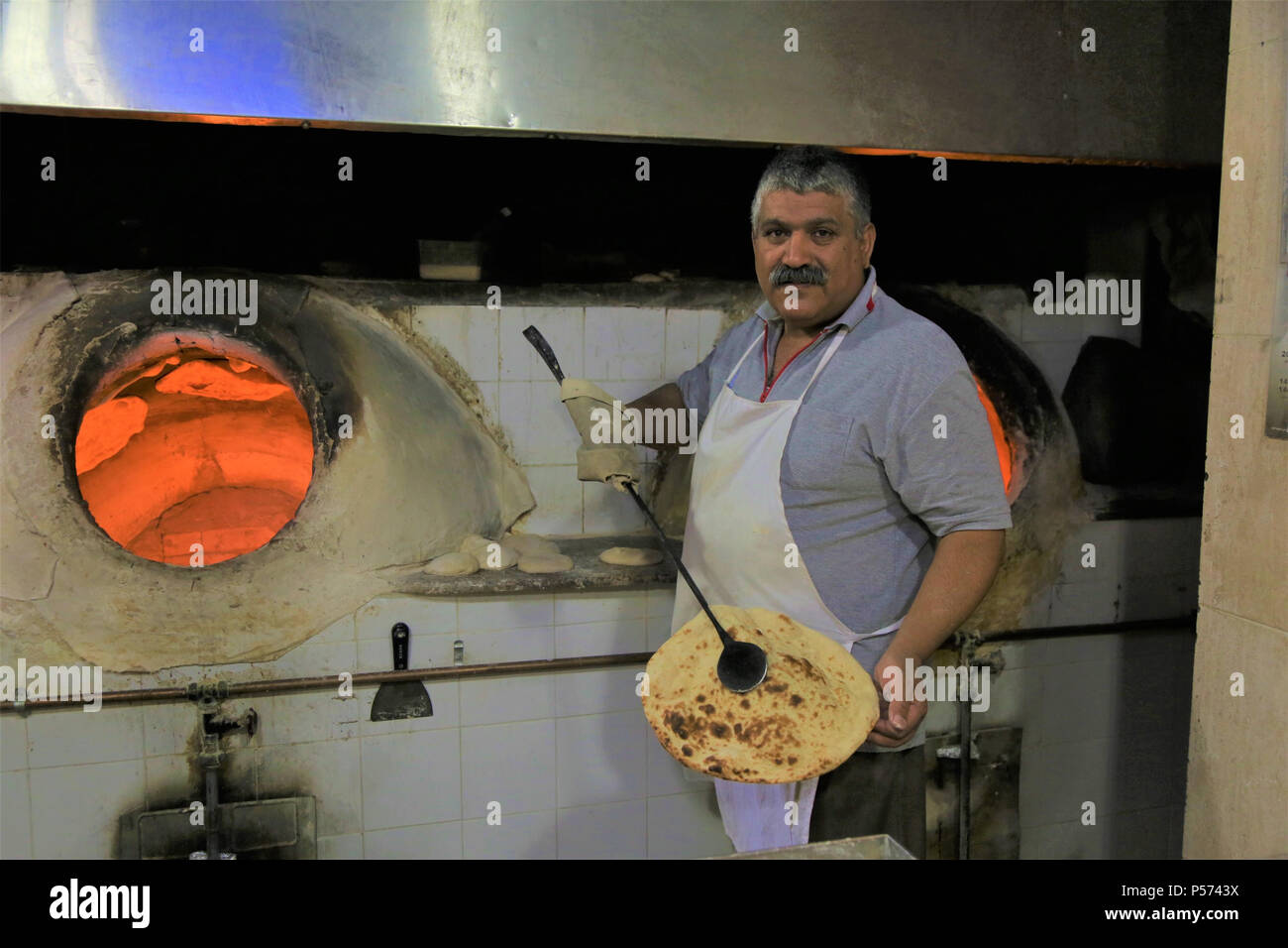 Kuwait City, Kuwait. 25th June, 2018. A man bakes arabic bread in his ...