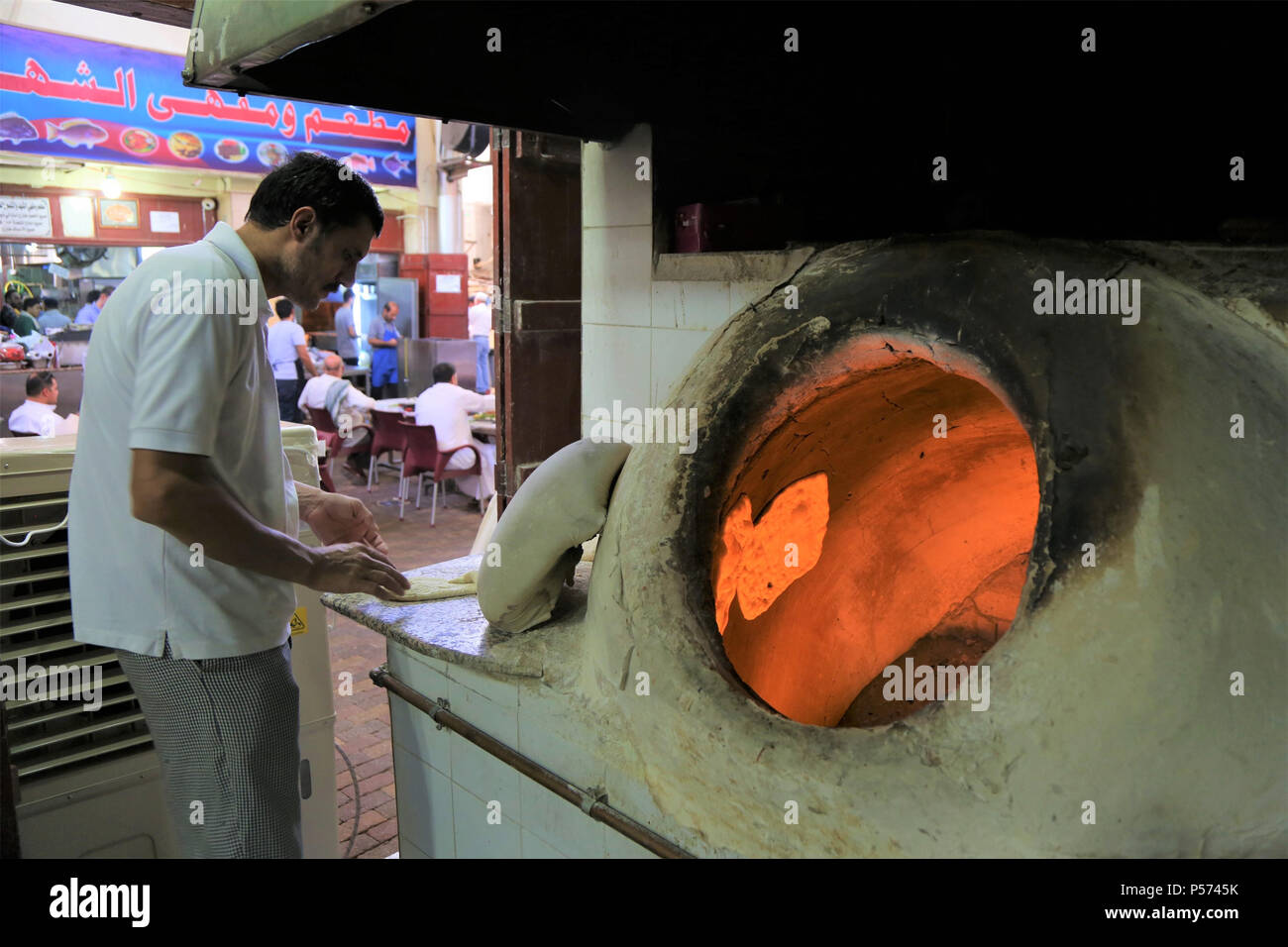Kuwait City, Kuwait. 25th June, 2018. A man bakes arabic bread in his ...