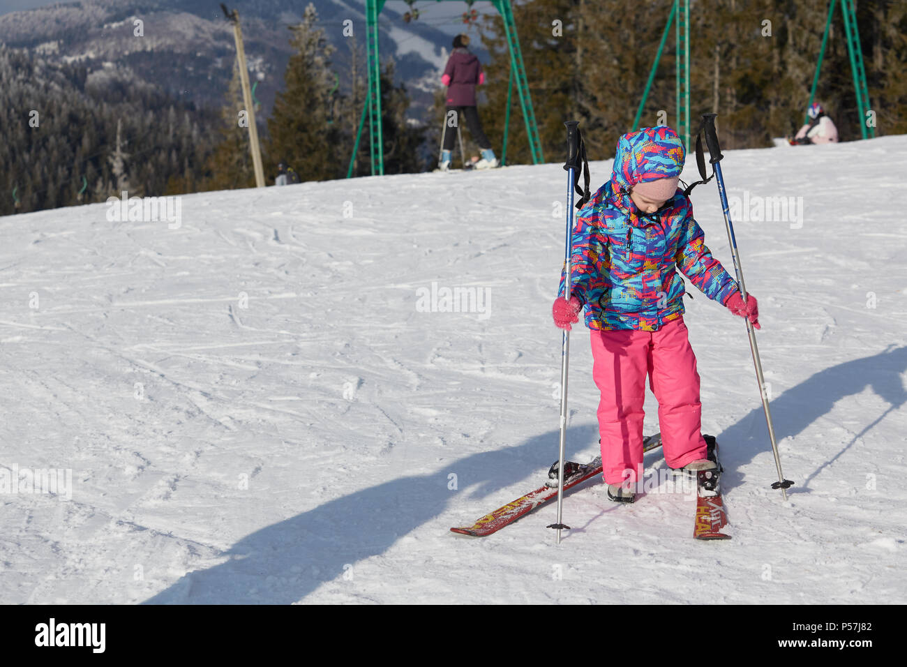 A happy little girl off skiing with slides Stock Photo - Alamy