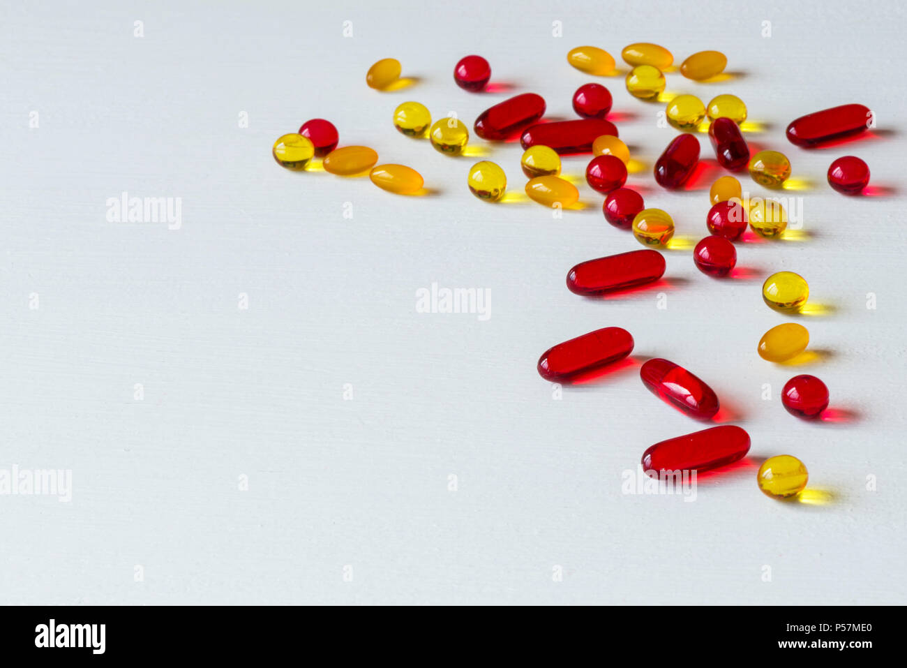 Red and yellow pills and capsules on white background. Copy space Stock ...