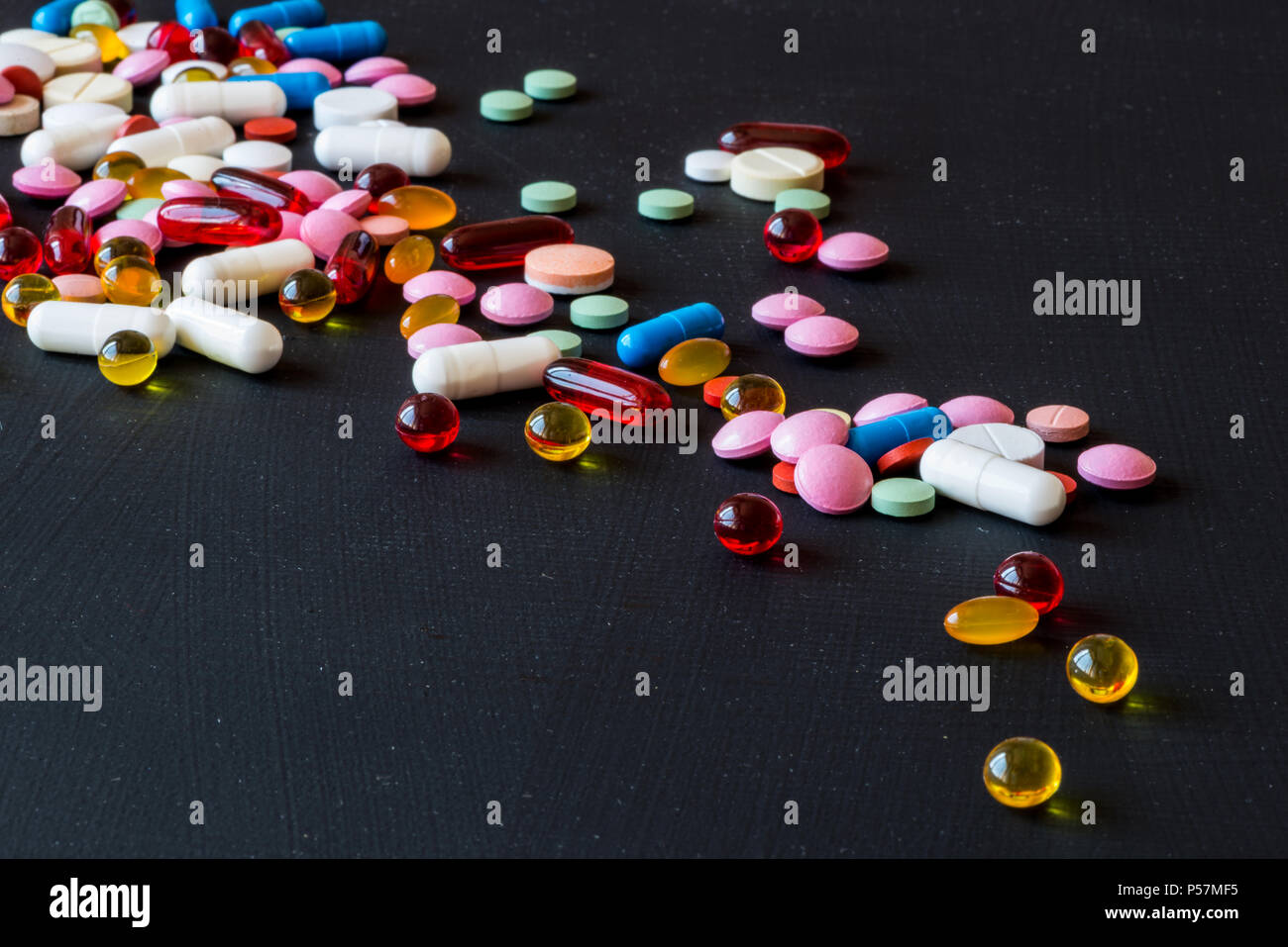 Different colorful medicines. Pills and capsules on black background ...