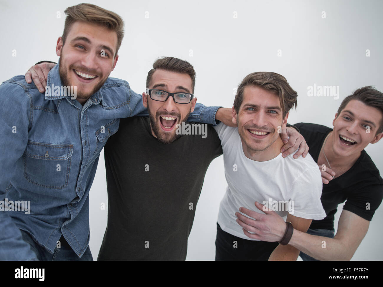 Four cheerful young guys stand and hug Stock Photo - Alamy