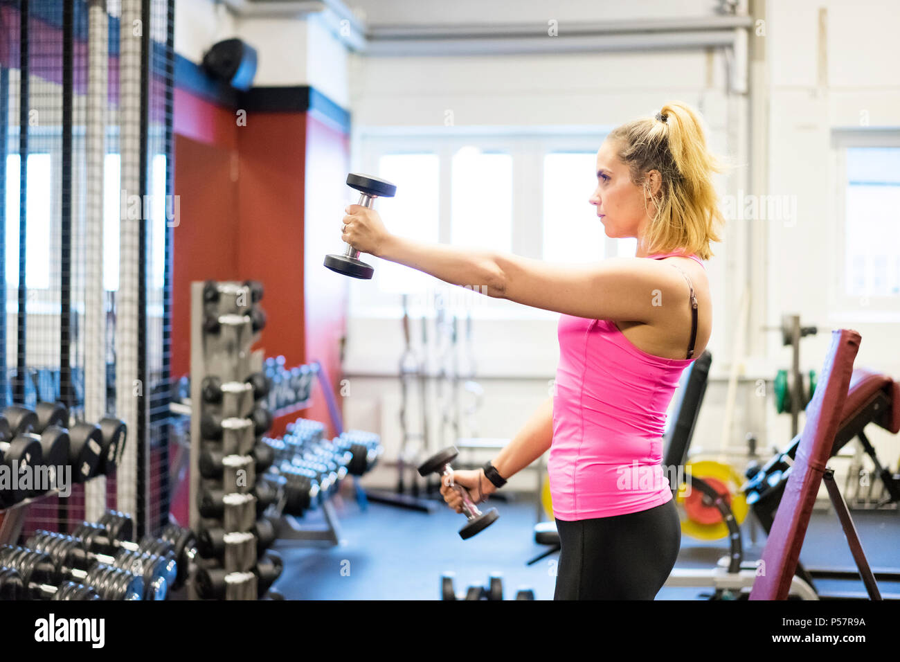 Caucasian blonde Scandinavian fitness girl training at gym. Strong ...