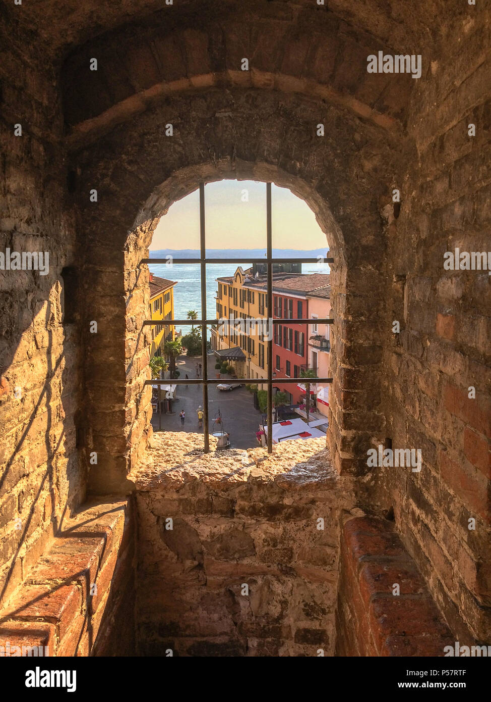 View through a castle window with lattice bars at the town of Sirmione ...