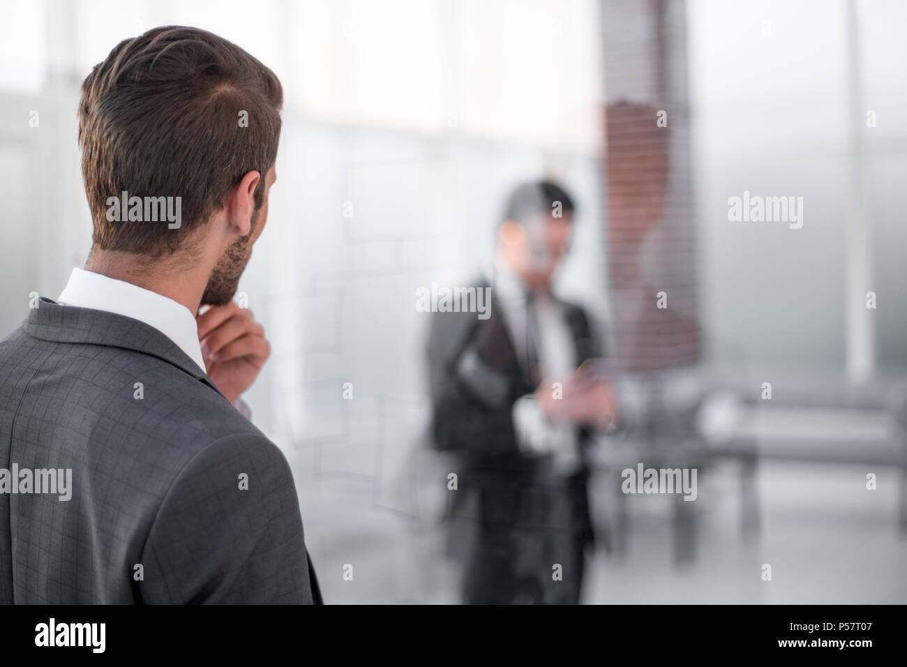 rear view.businessman looks out the window of the Bank Stock Photo - Alamy