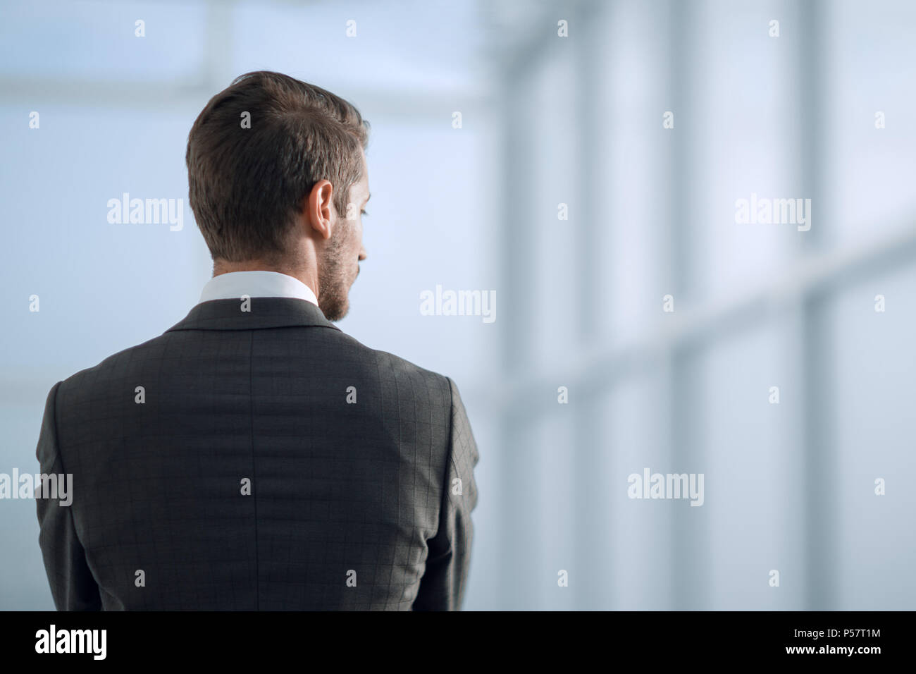 rear view.businessman standing near the office window Stock Photo - Alamy