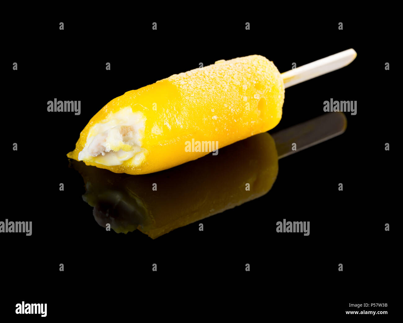 studio shoot yellow popsicle on a black background with some bites ...