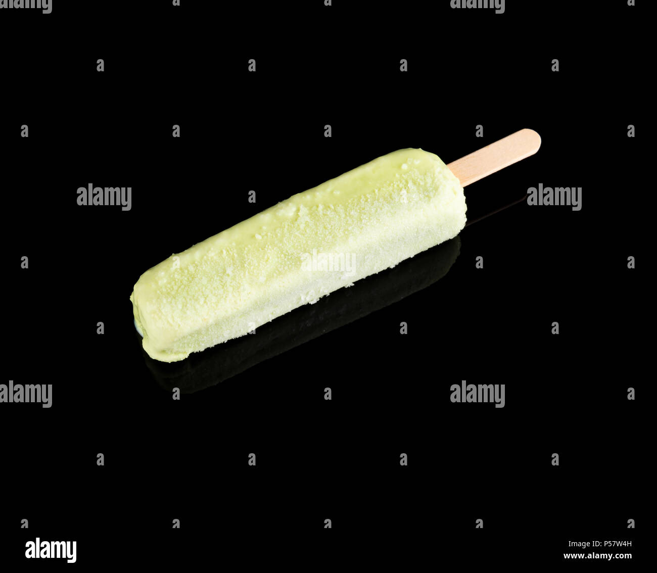 green popsicle starts melting on a black background Stock Photo - Alamy