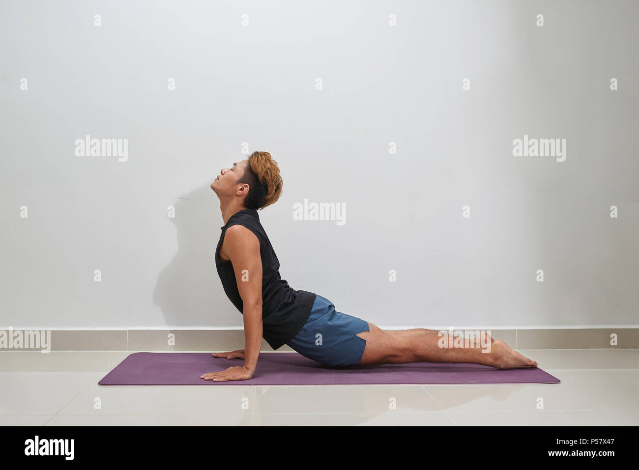 Fitness man plank workout training at white background indoors. Young ...