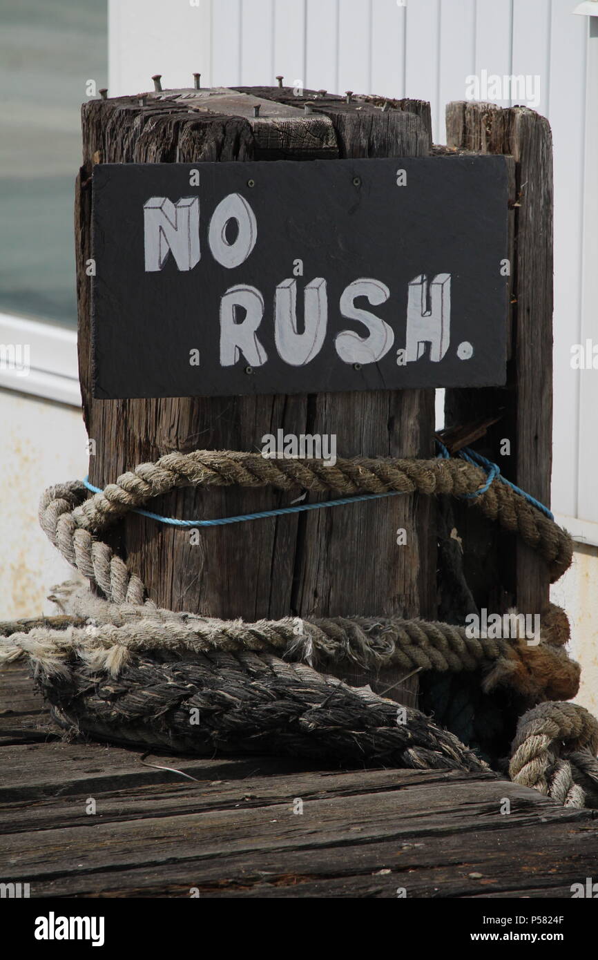 'No Rush' Sign attached to mooring at the harbour's edge. Essex ...