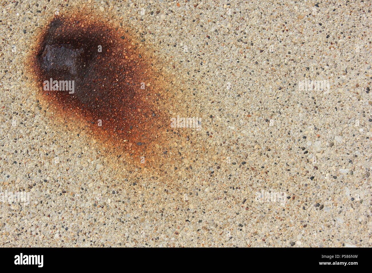 Rust spot on a concrete sidewalk due to exposed and now rusted steel ...