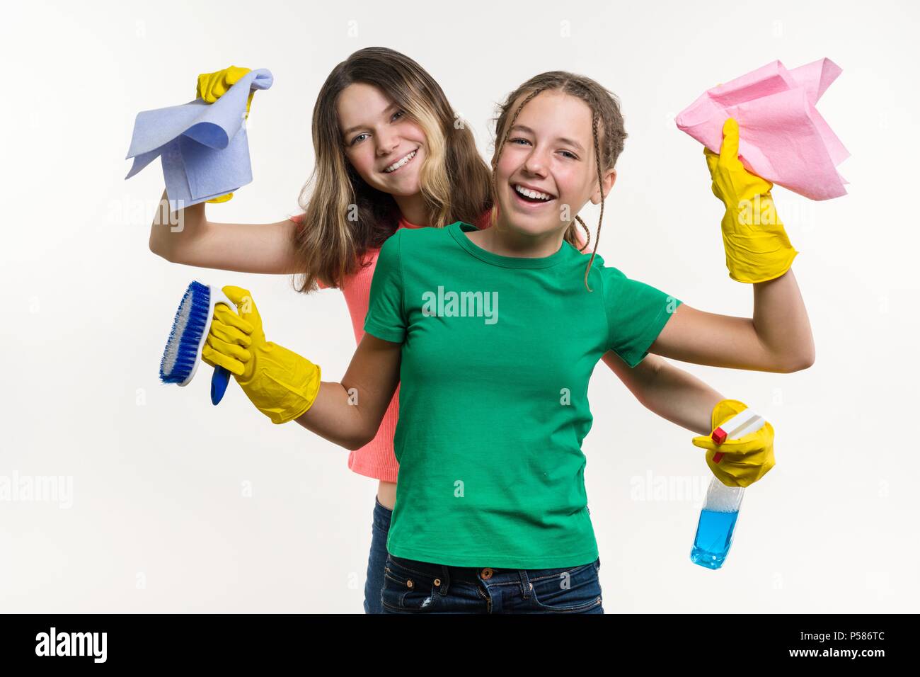 Cleaning, domestic duties and teamwork concept. Two teenage sisters ...