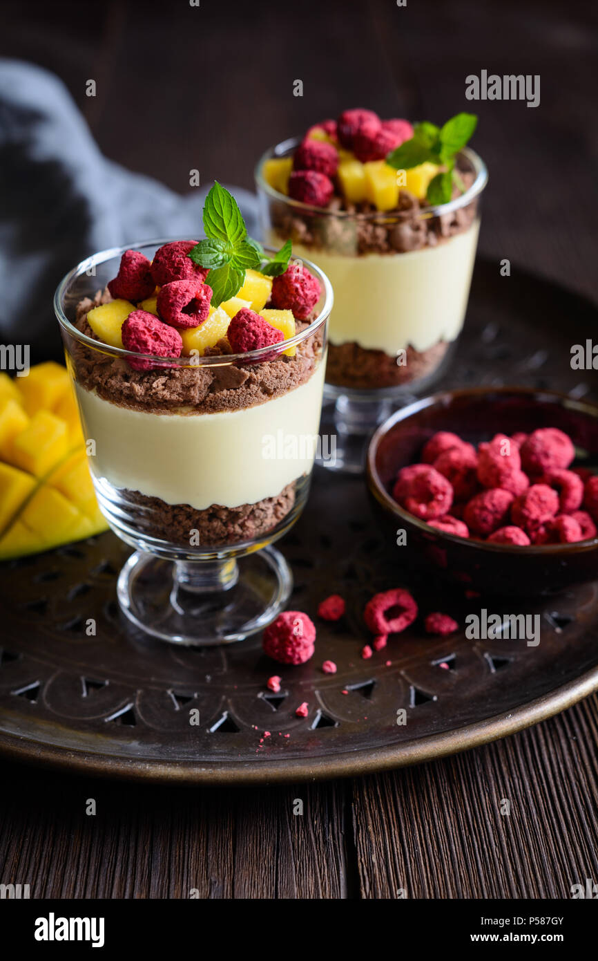 Layered mango dessert with cream cheese, crushed biscuits and freeze ...