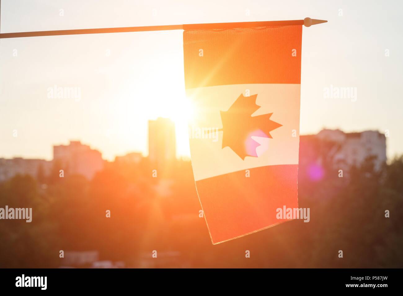 Flag of Canada from window on sunset background Stock Photo - Alamy