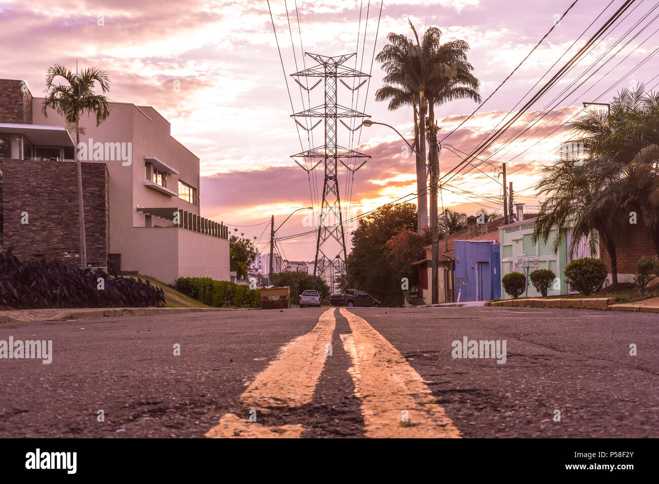 Street leading to a high voltage power tower against sunset sky Stock ...