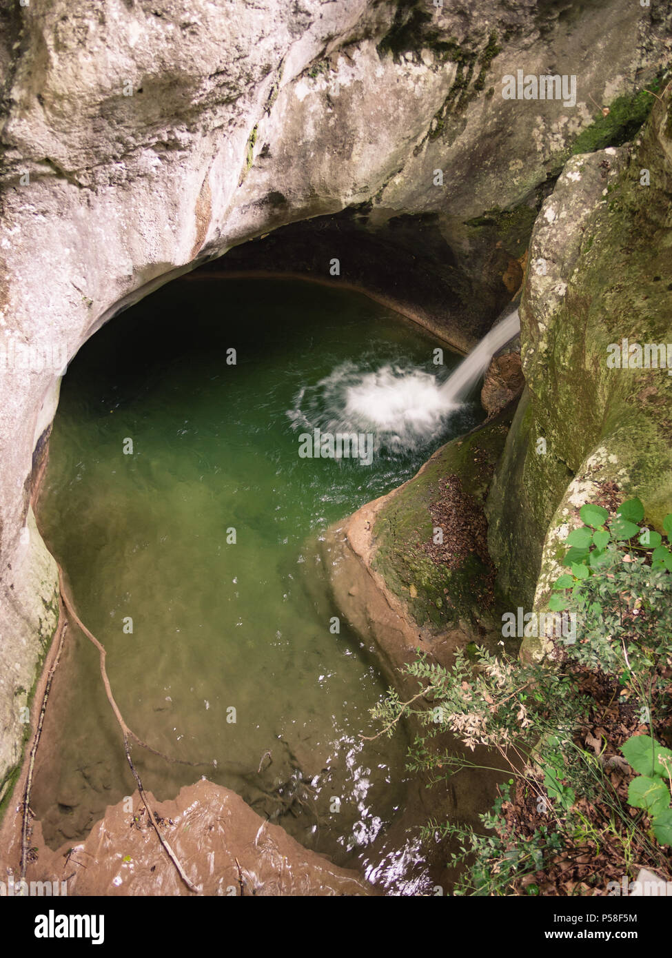 Small waterfall at the entrance to a natural cave in the rock Stock ...