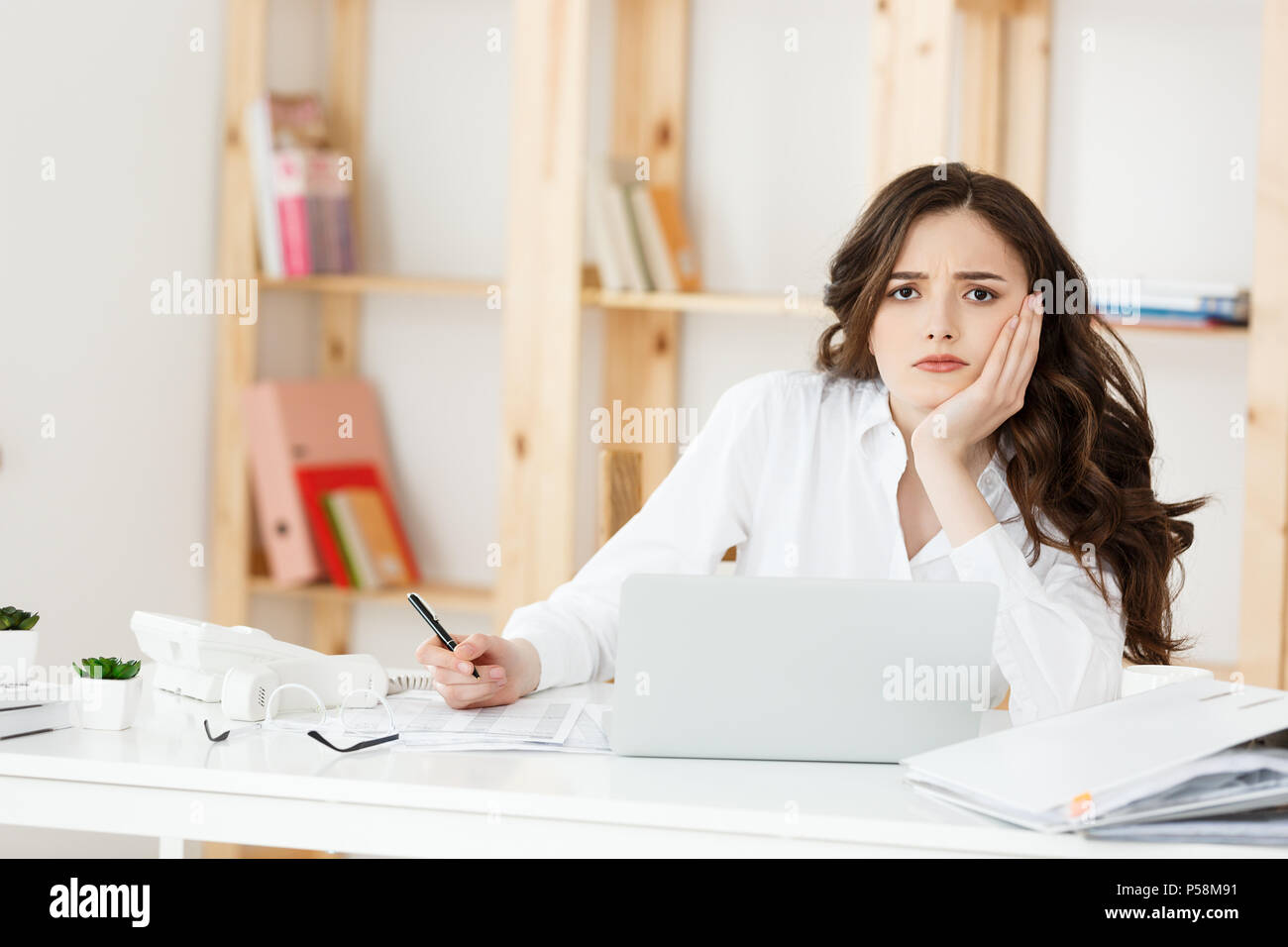 Tired beautiful Businesswoman holding hand on head while working on ...