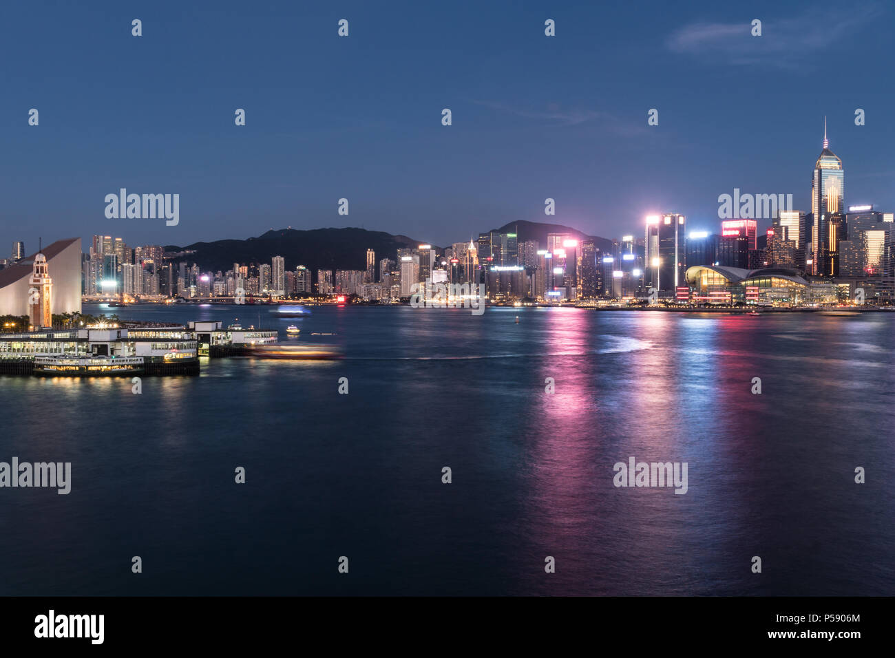 The Star Ferry pier in Tsim Sha Tsui in Kowloon with the skyline of Hong Kong island business ...