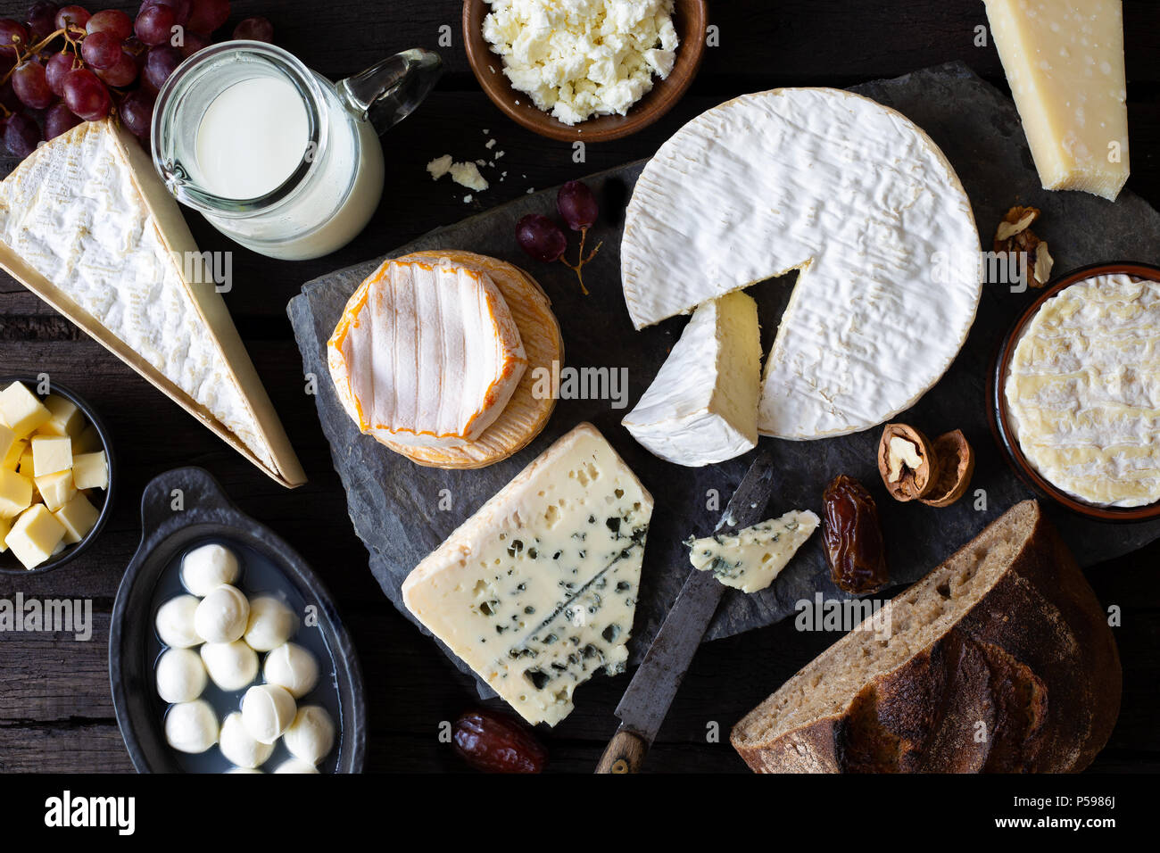 Cheese, milk and dairy products on rustic dark wood and slate ...