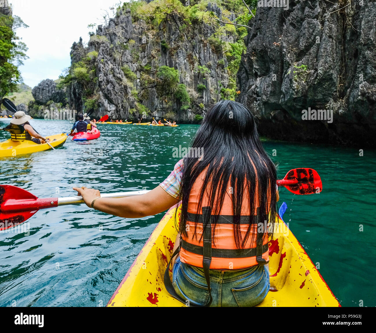 Palawan, Philippines - Apr 5, 2017. A woman paddling kayak on blue sea ...