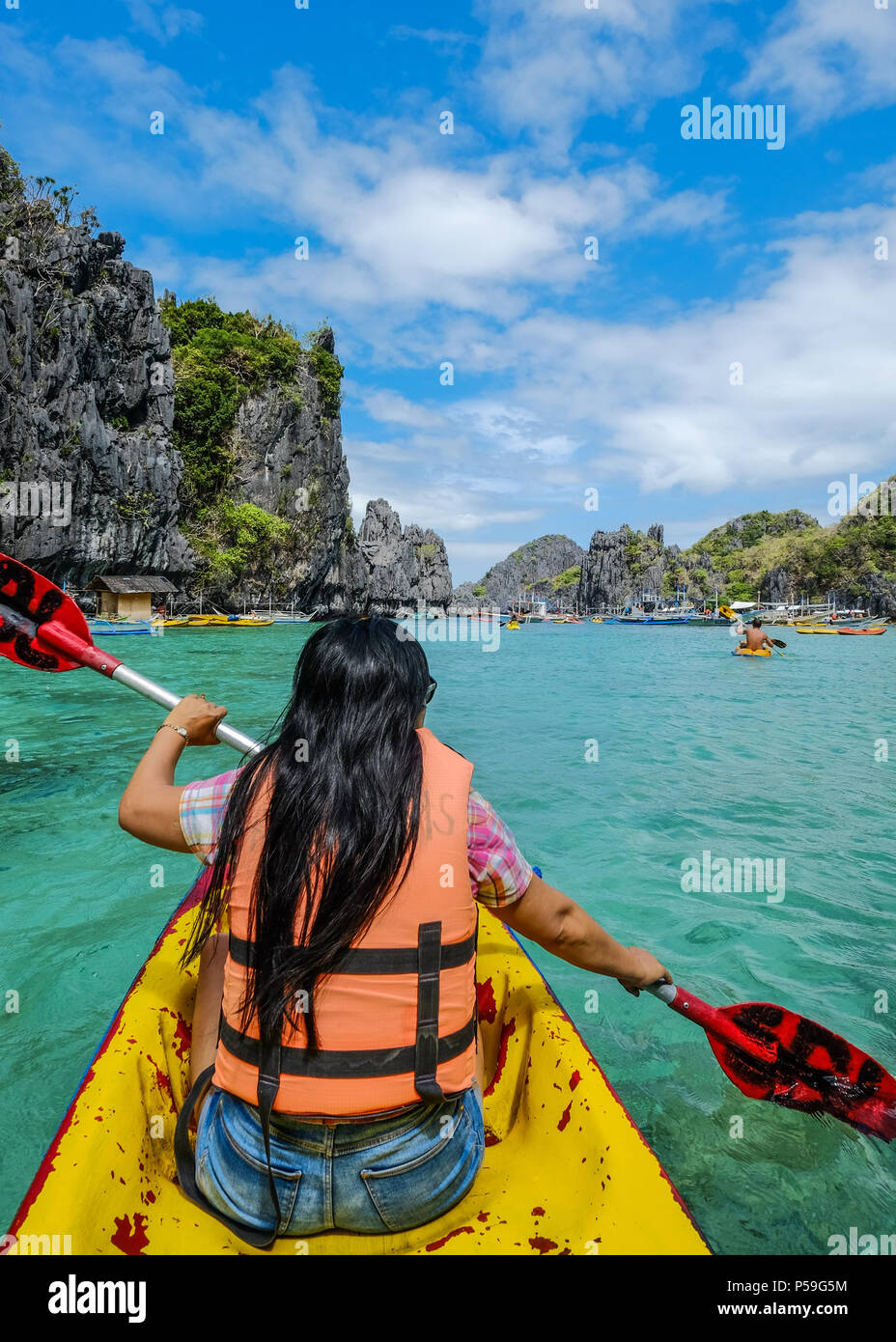Palawan, Philippines - Apr 5, 2017. A woman paddling kayak on blue sea ...