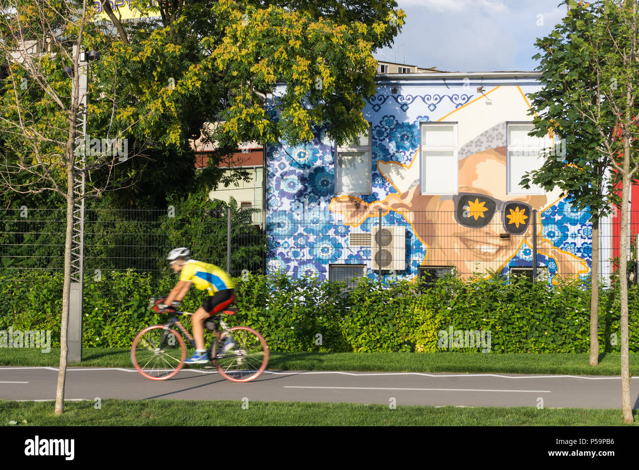 A cyclist rides past the building of KC Grad in the Savamala district ...