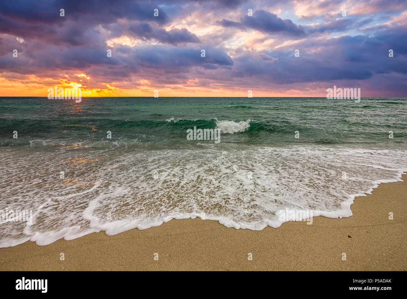 Beautiful sunrise over the sea. Wave pattern Stock Photo - Alamy