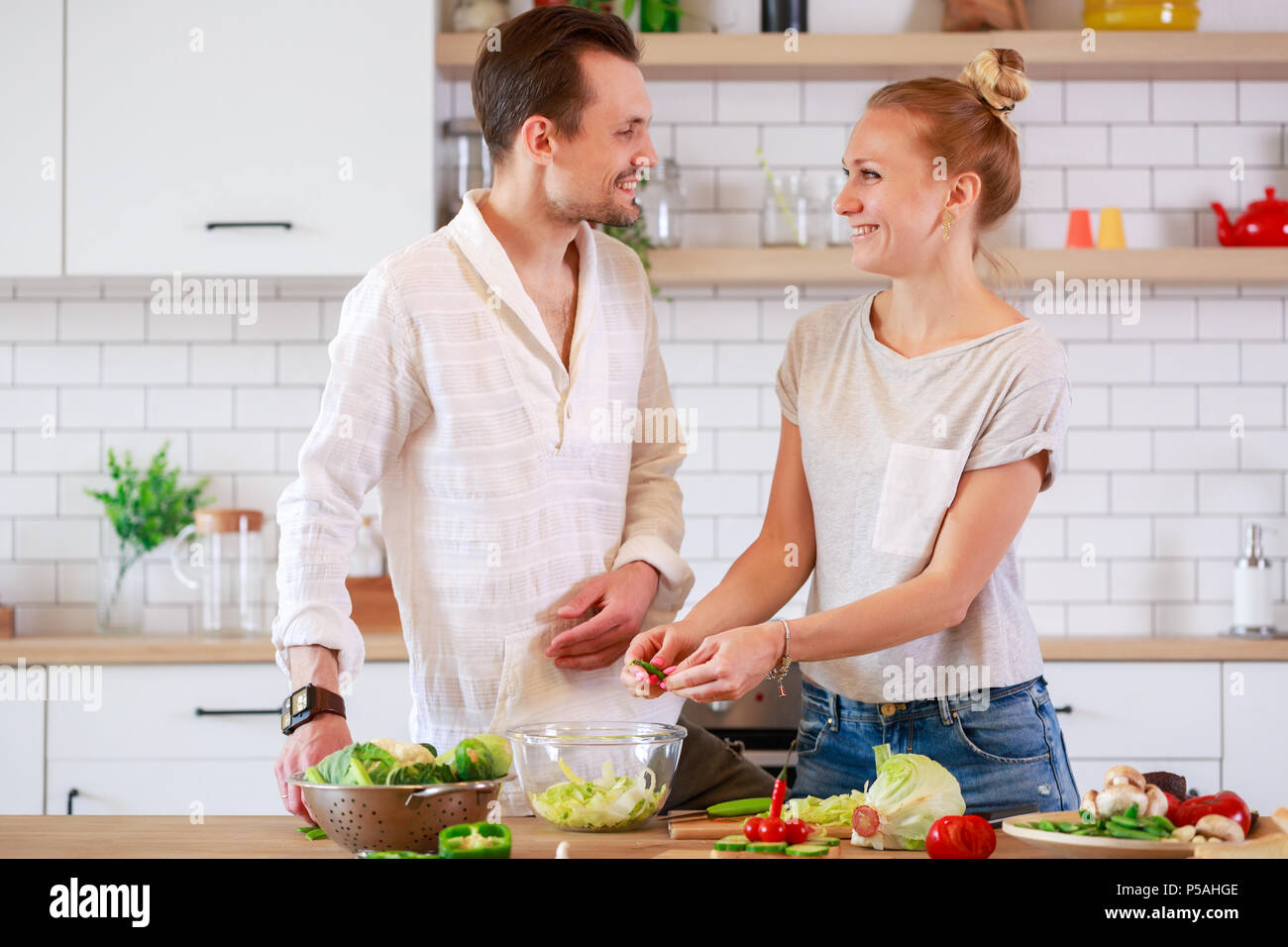 Photo of beautiful man and woman cooking vegetables in the kitchen ...