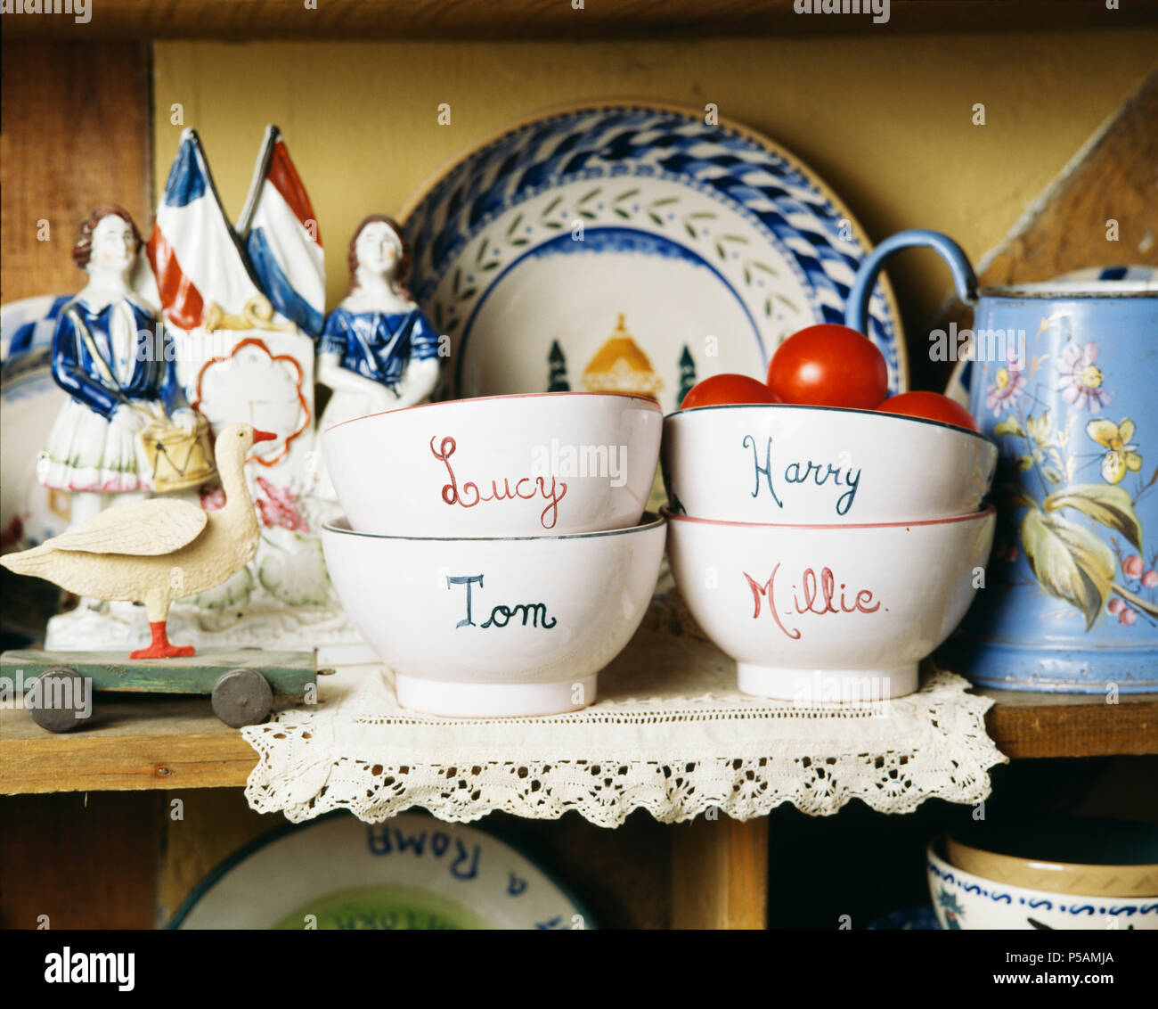 Close-up of pottery bowls inscribed with names on shelf with ...
