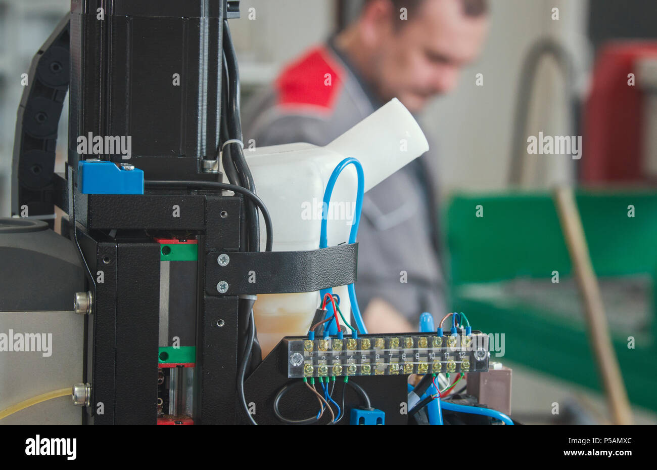 Working CNC machine at factory with lathes, man in uniform at ...
