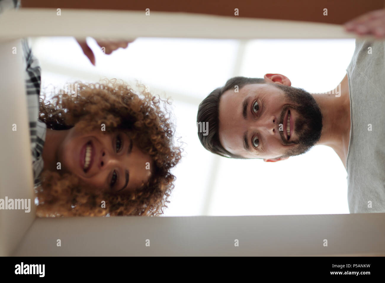 View from below a young couple looking inside the box Stock Photo - Alamy