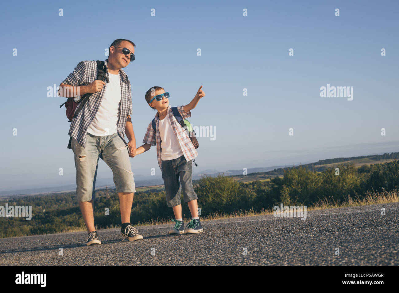 Father and son standing on the road at the day time. Concept of tourism ...