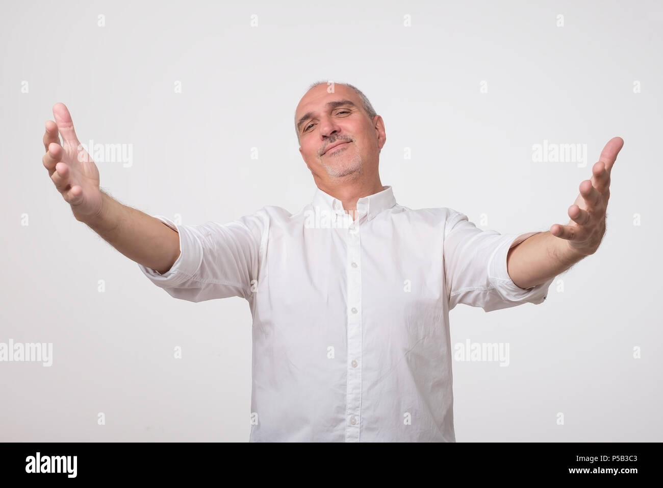 You are welcome concept. Cheerful mature man in white shirt gesturing ... You are welcome concept. Cheerful mature man in white shirt gesturing ...