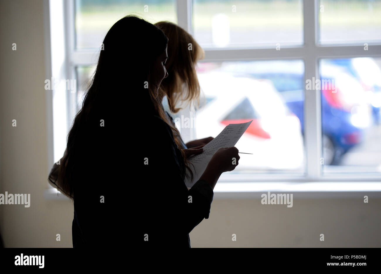 A generic unrecognisable teenage girl silhouetted looking at exam ...