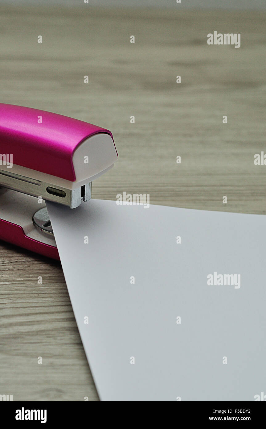 A pink stapler with papers Stock Photo - Alamy