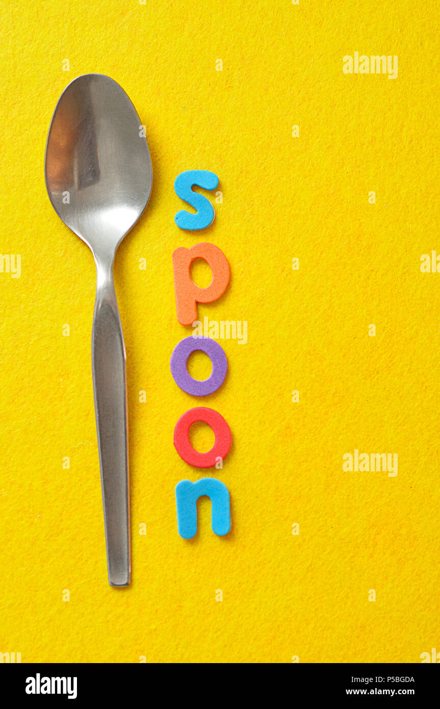 The word spoon displayed with a spoon on a yellow background Stock ...