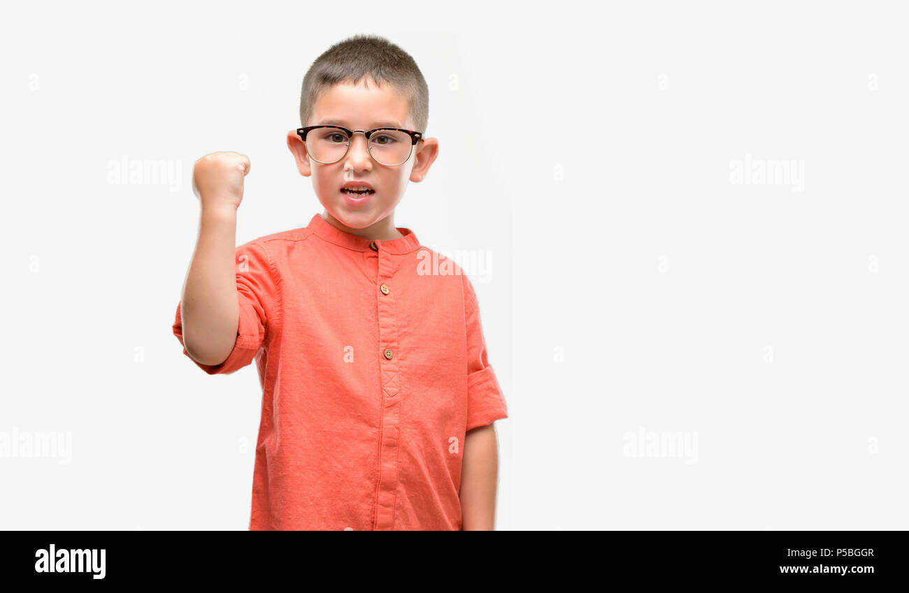 Dark haired little child wearing glasses annoyed and frustrated ...