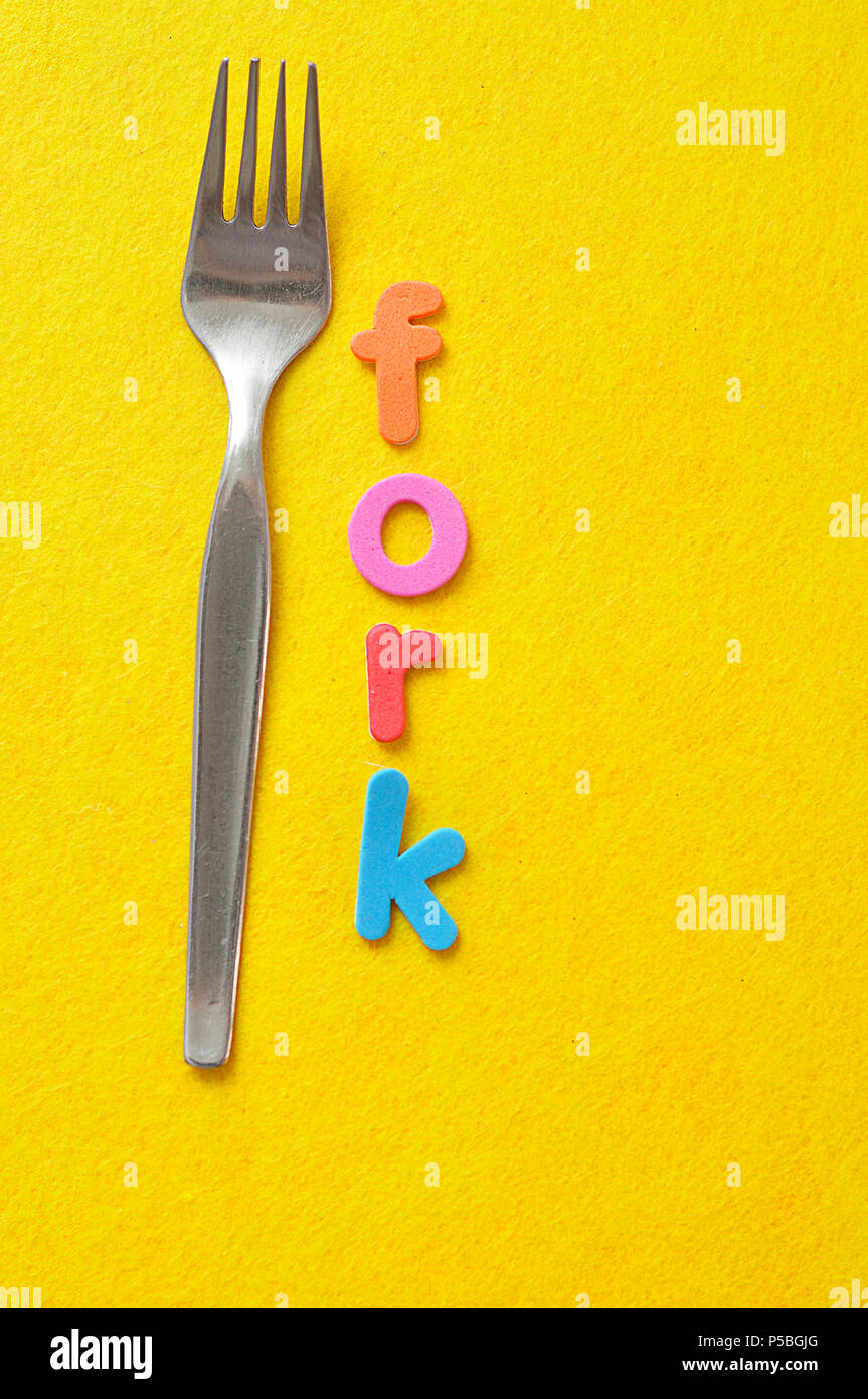 The word fork displayed with a fork on a yellow background Stock Photo ...