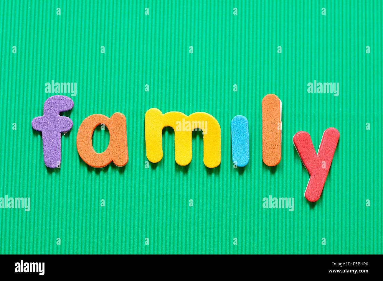 The word family in colorful letters on a green background Stock Photo ...