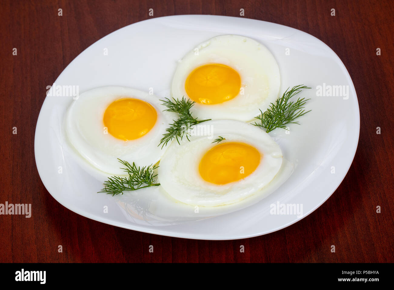 Fried three eggs served dill Stock Photo - Alamy