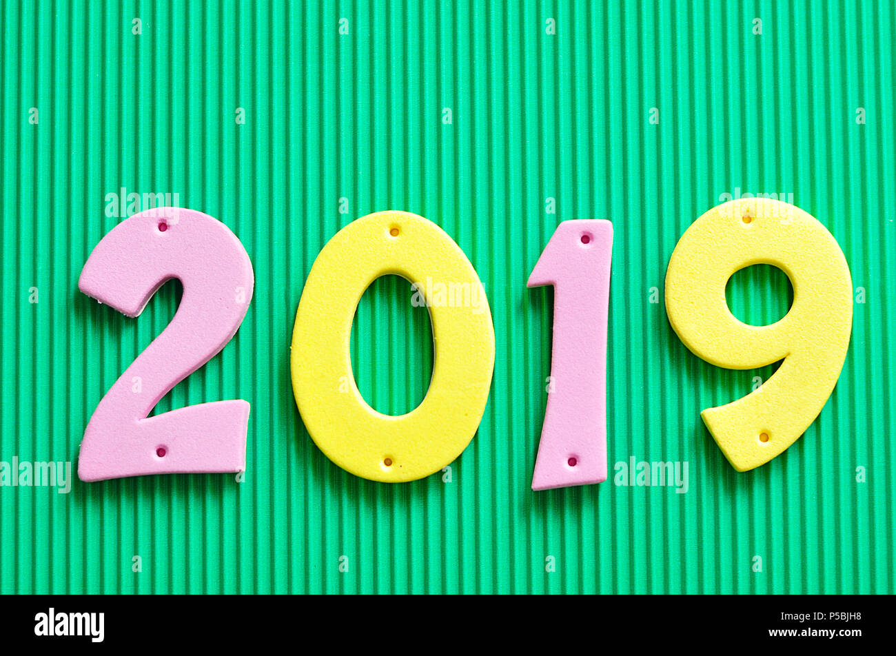 2019 in pink and yellow numbers on a green background Stock Photo - Alamy