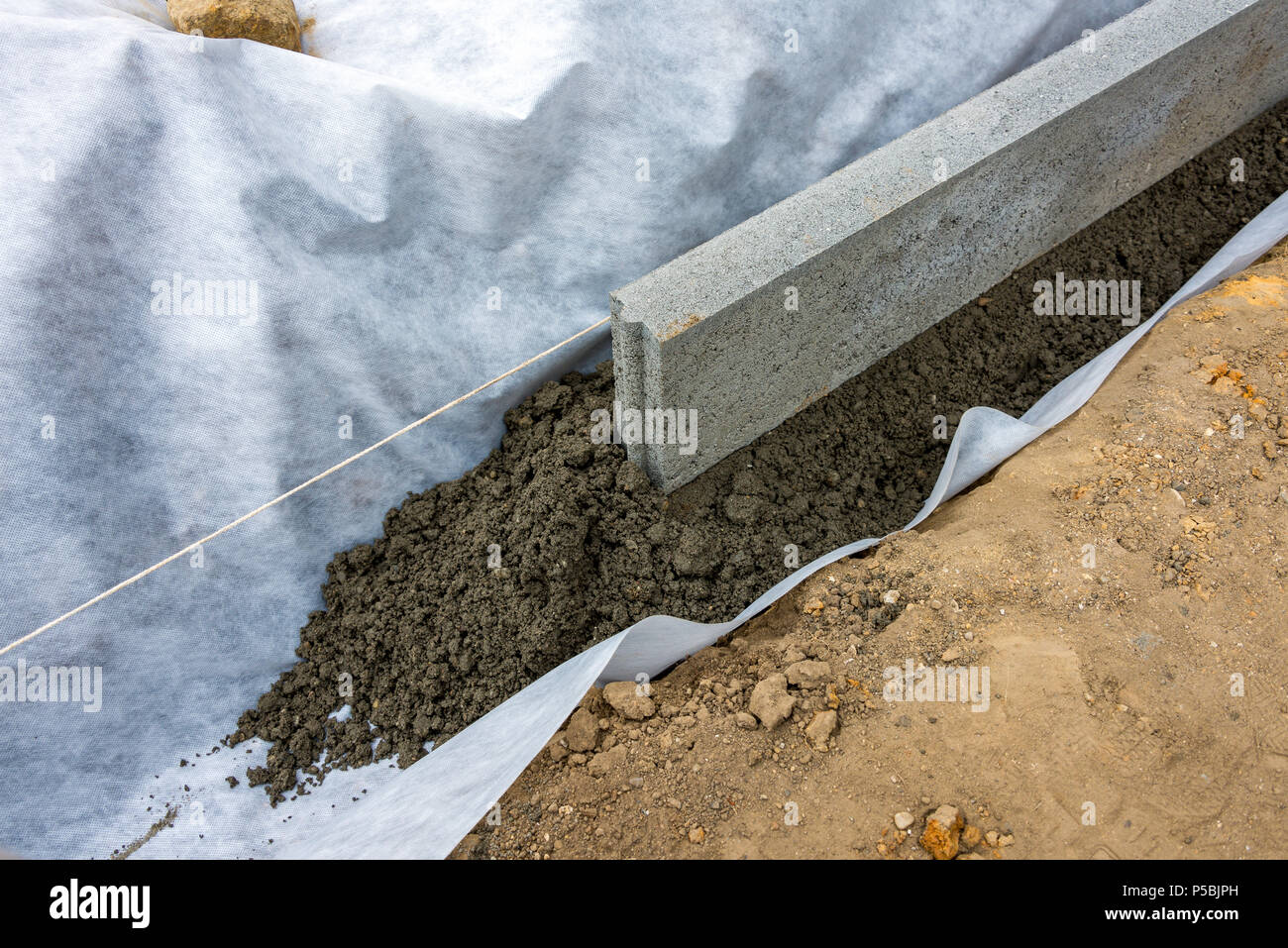 Setting edge restraints buy putting border curb stones in earth-moist ...