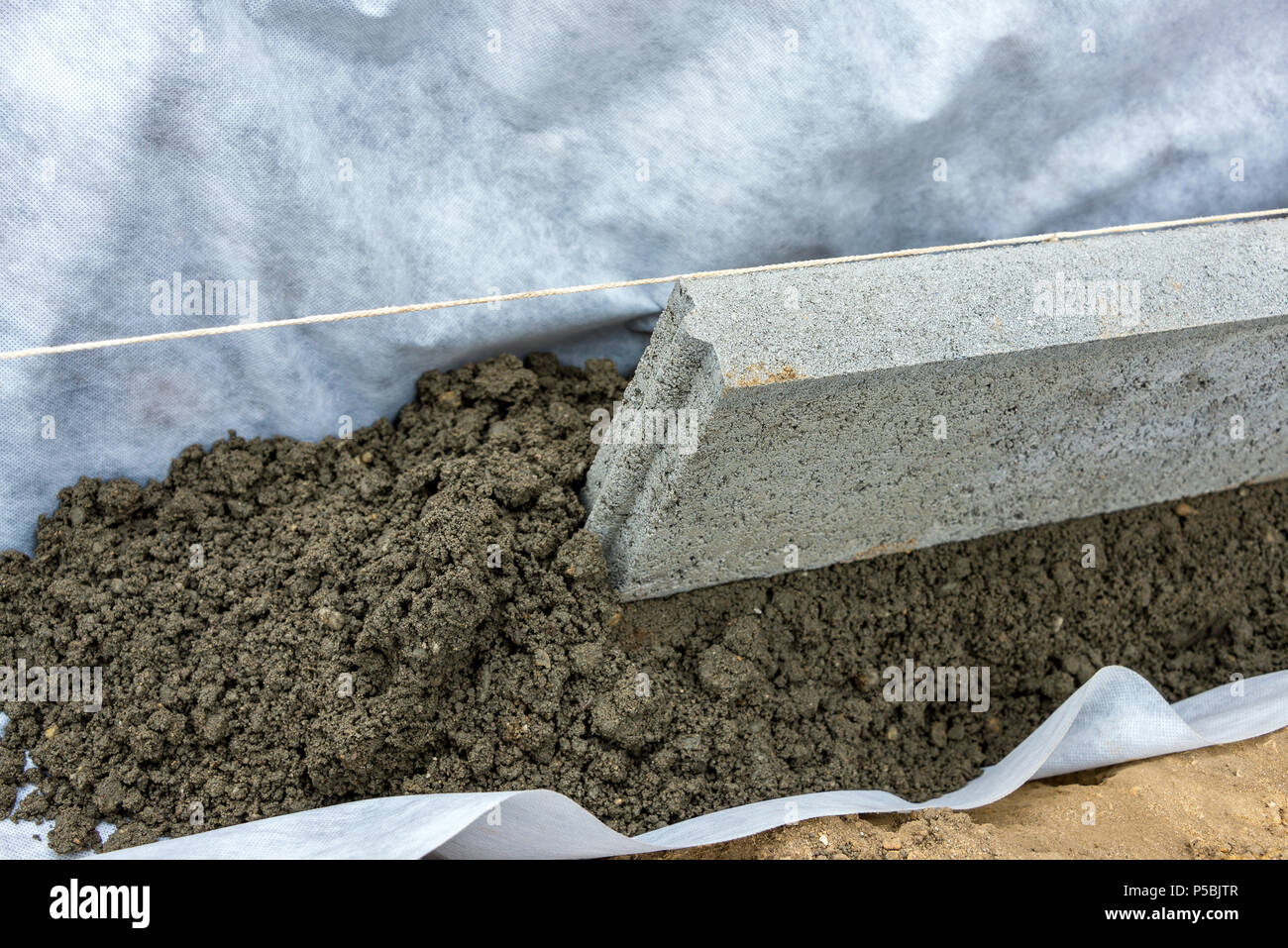 Setting edge restraints buy putting border curb stones in earth-moist ...