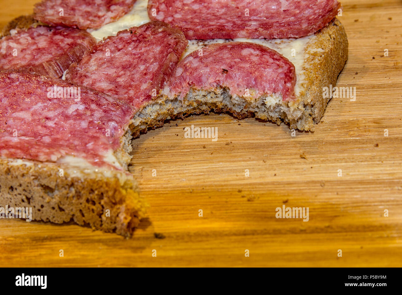 a bitten slice of salami. Lean breakfast. Bitten sandwich. Close up ...