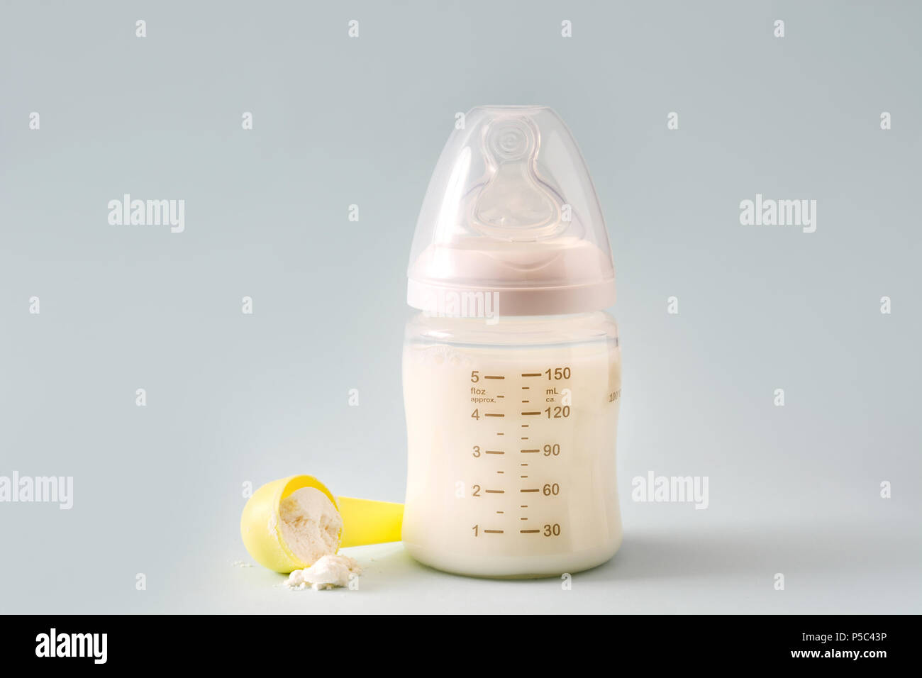 Baby bottle and milk on gray background Stock Photo - Alamy