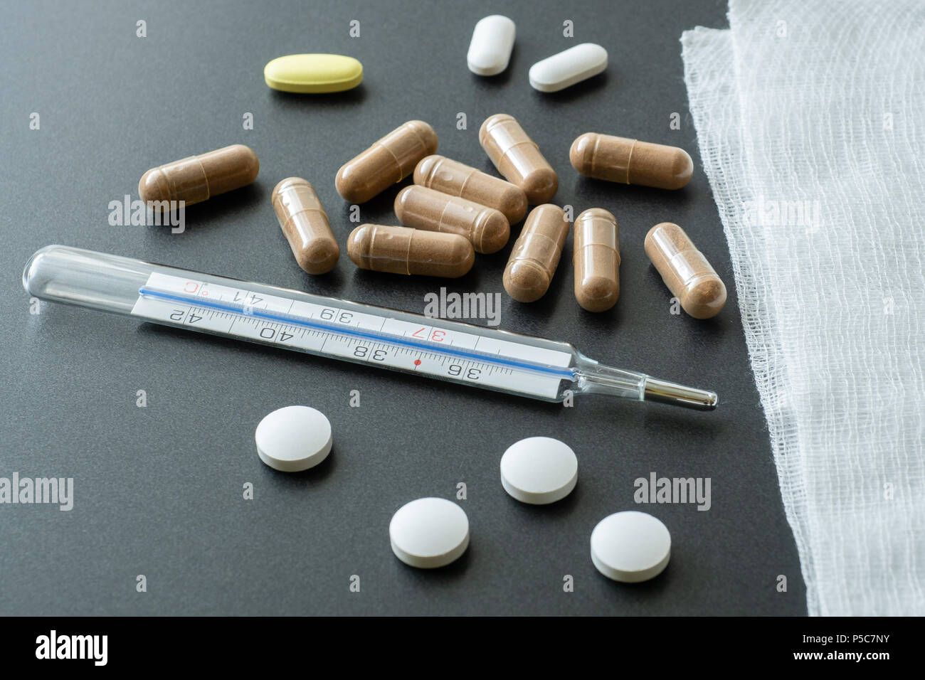 Traditional medical thermometer for measuring body temperature. Pills ...